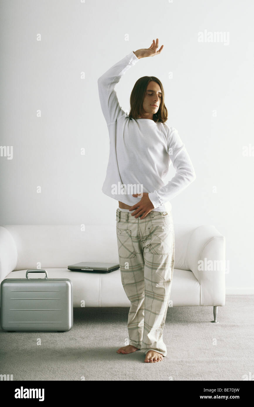 Man standing with one arm raised, eyes closed Stock Photo - Alamy