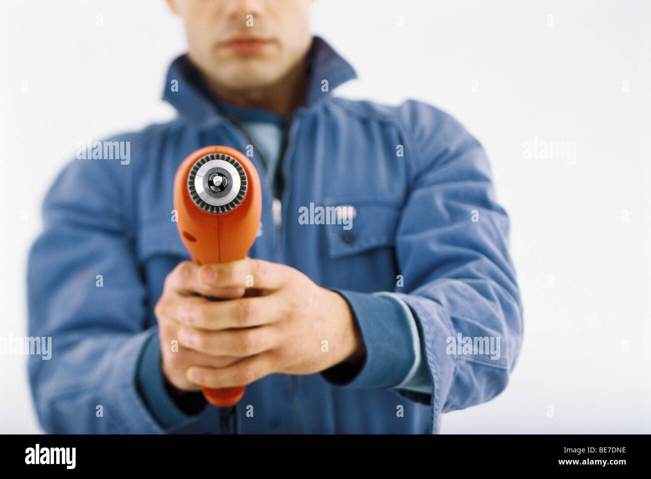 Man pointing drill at camera, cropped Stock Photo - Alamy