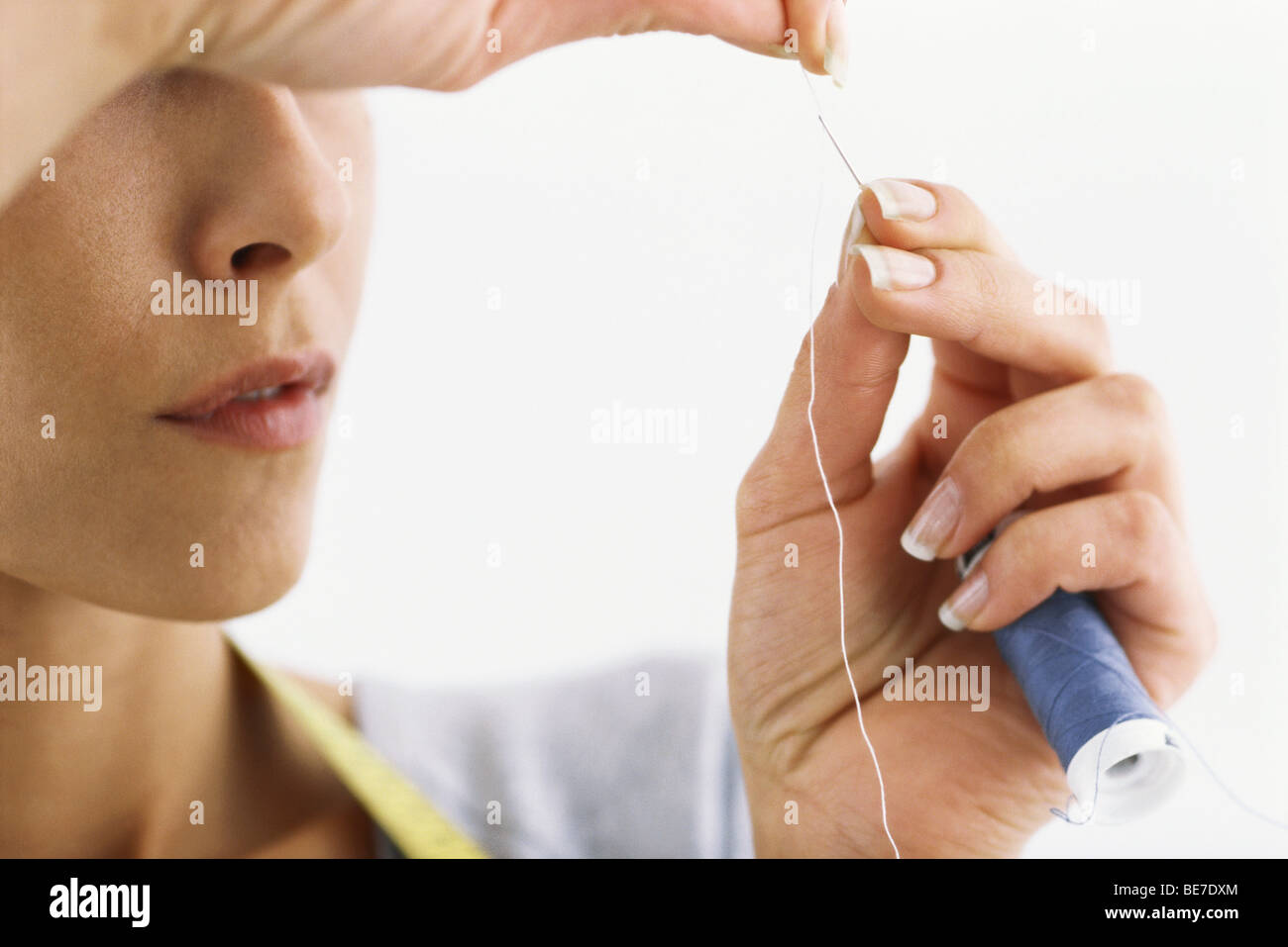 Woman threading needle, cropped Stock Photo - Alamy