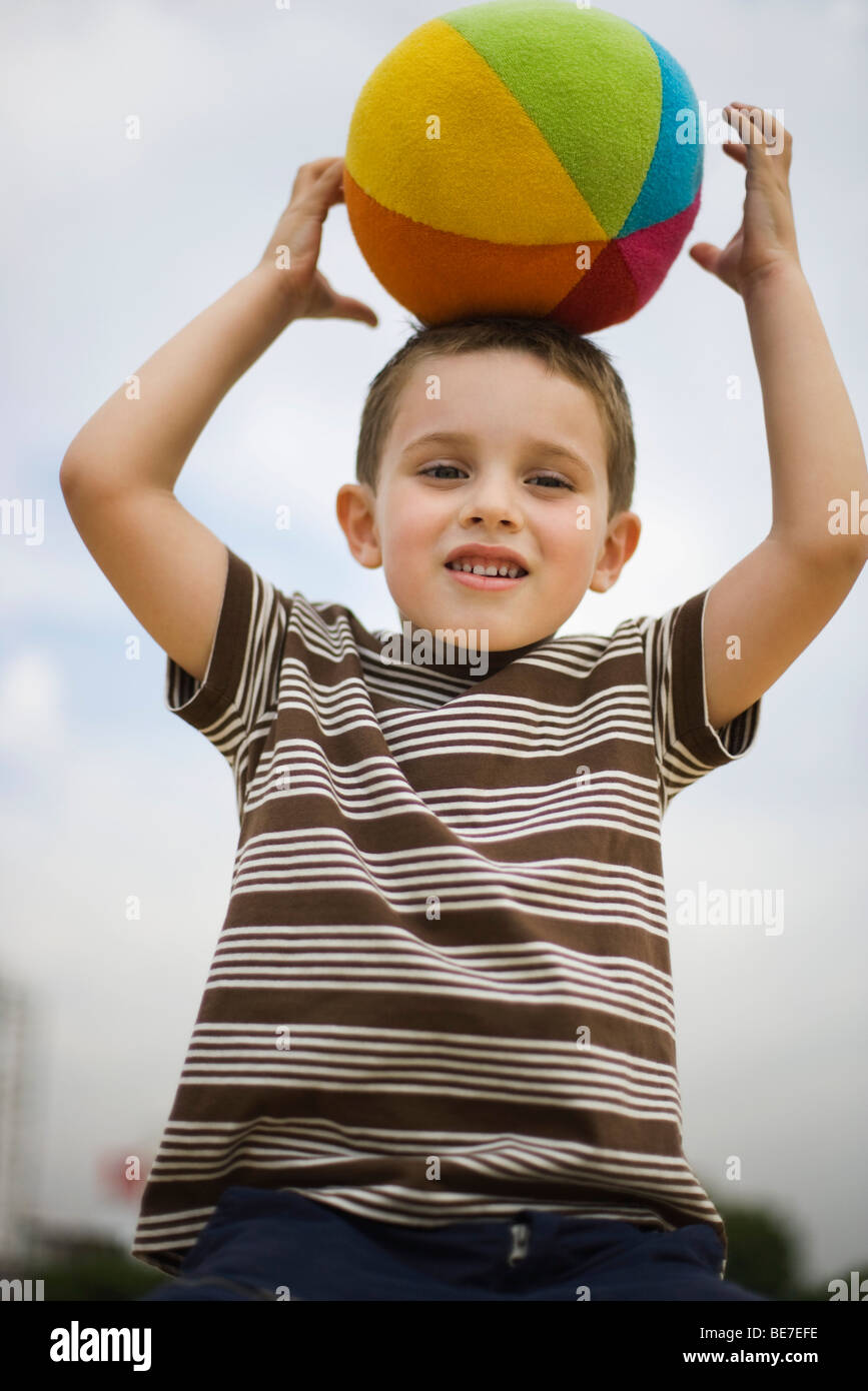Boy balancing ball on head Stock Photo - Alamy