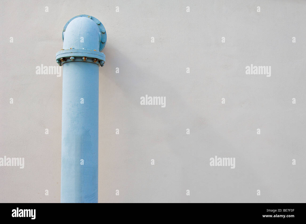big blue pipe against wall background Stock Photo - Alamy