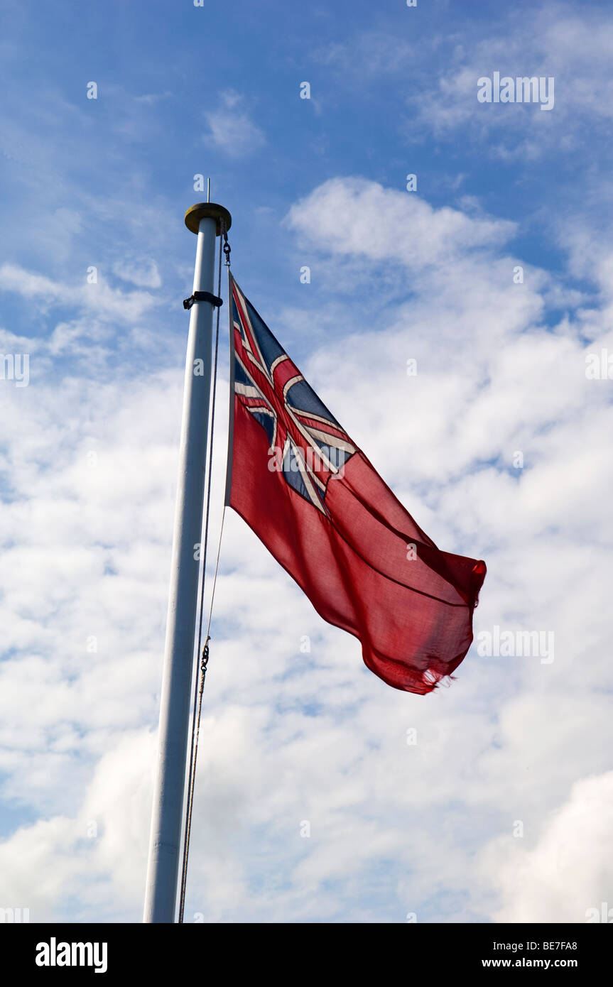 Union Jack flag blowing in wind on pole with background of clouds and ...