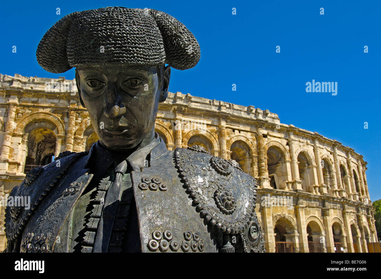Roman amphitheatre and bullfighter statue. Arenes, Nimes, Gard. Bouches ...