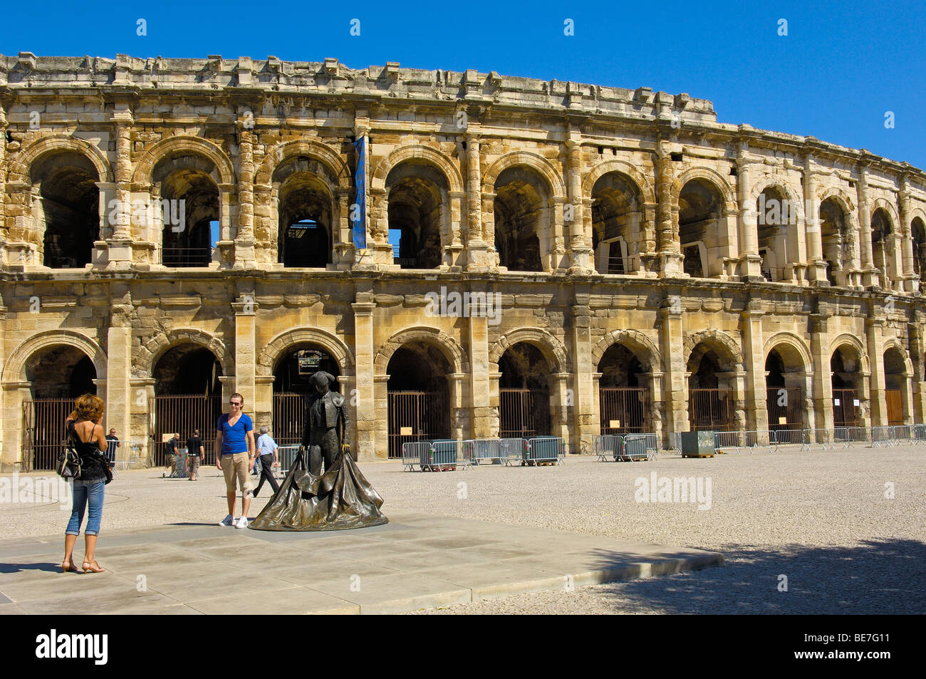 Roman amphitheatre and bullfighter statue. Arenes, Nimes, Gard. Bouches ...
