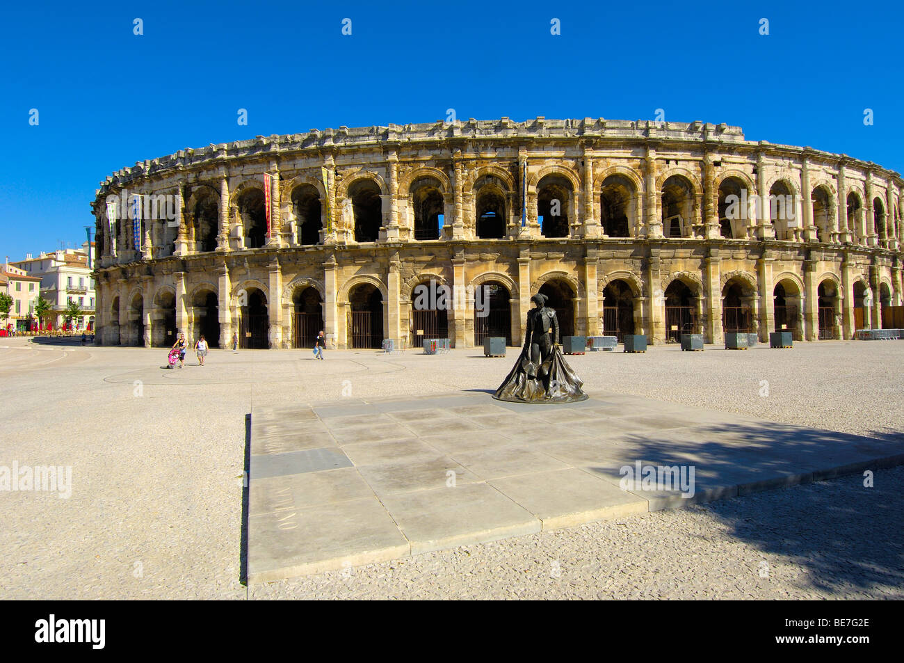 Roman amphitheatre and bullfighter statue. Arenes, Nimes, Gard. Bouches ...