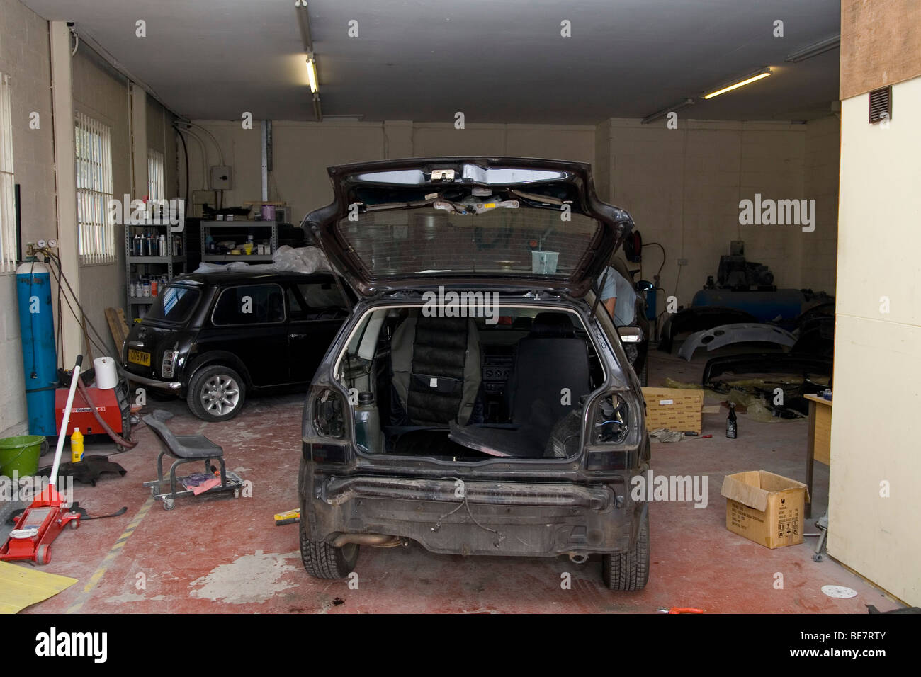 A car workshop with cars awaiting repair Stock Photo - Alamy