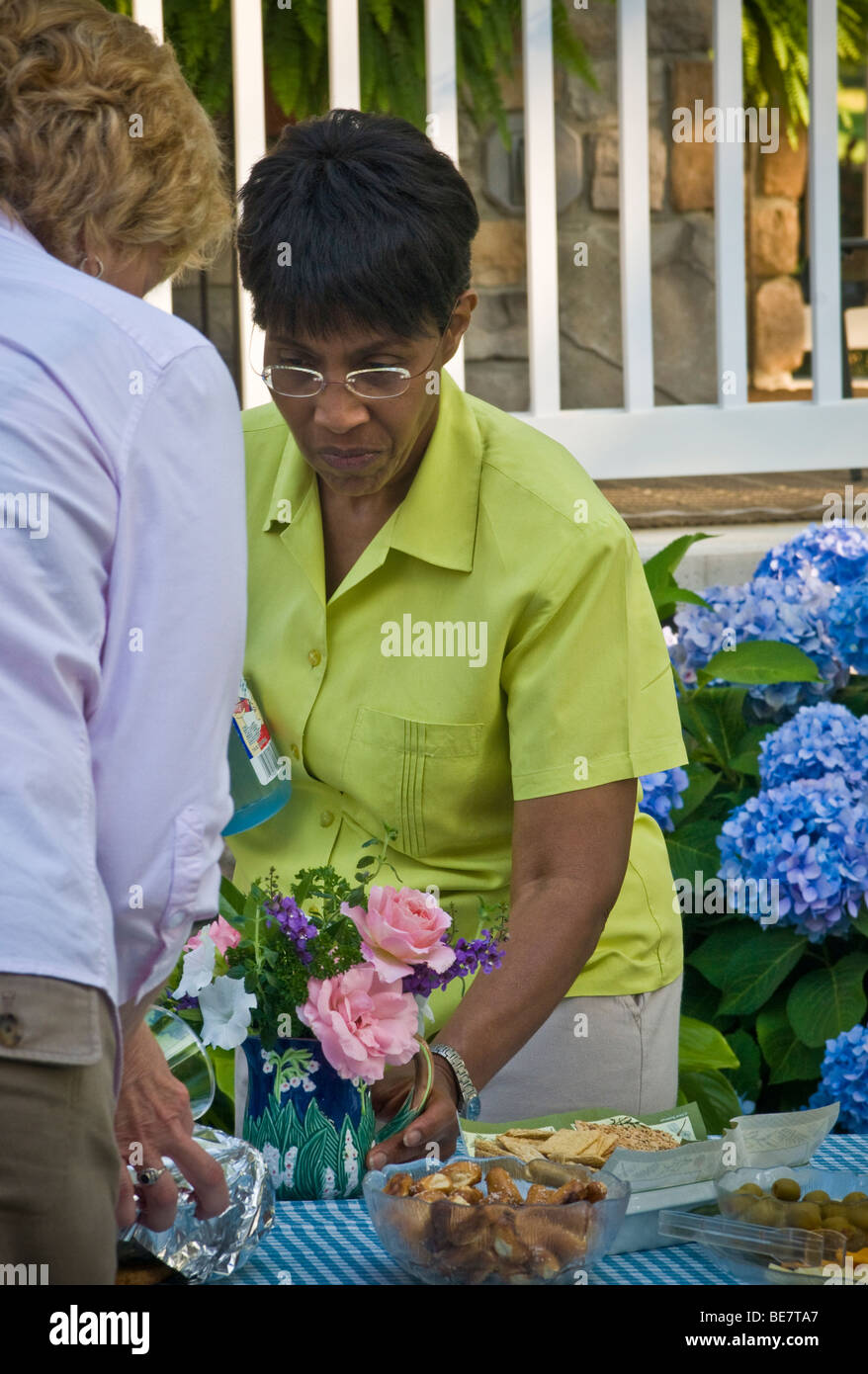Two women prepare flowers for neighborhood picnic outing Stock Photo ...