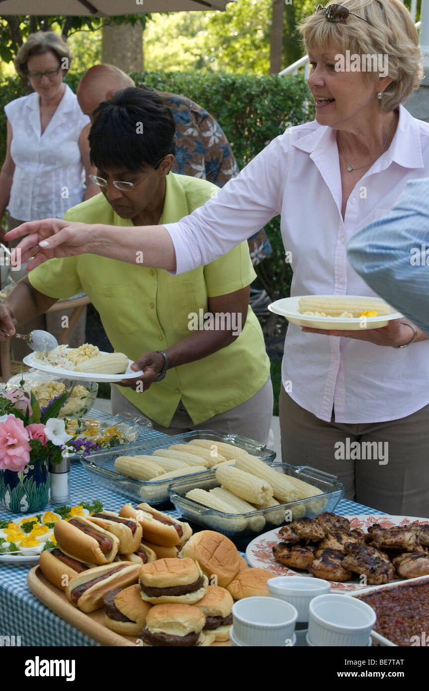 Neighborhood picnic buffet table with hot dogs, hamburgers, bbq chicken ...