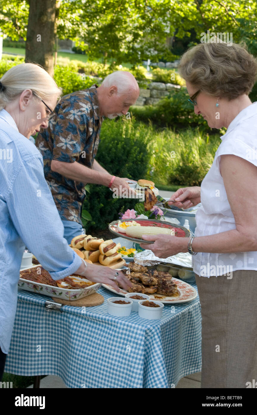 Neighborhood picnic buffet table with hot dogs, hamburgers, bbq chicken ...