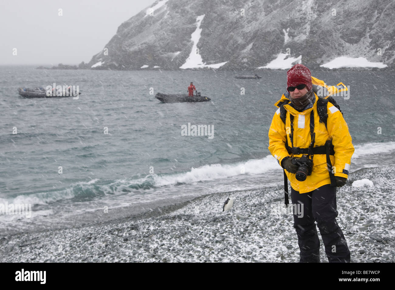 Cold working professional photographer with camera standing on rocky ...