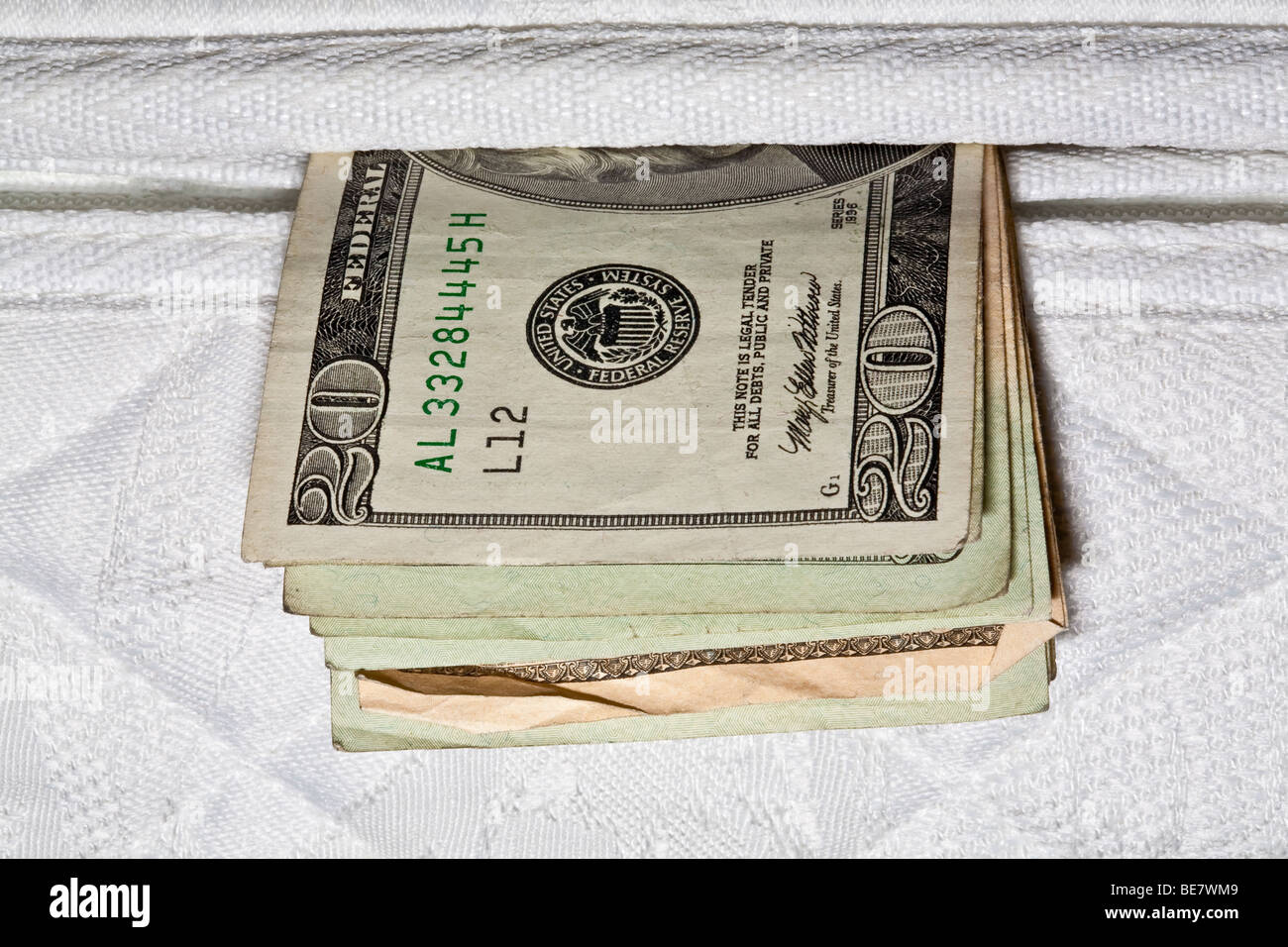US twenty dollar paper currency protruding from under mattress Stock ...