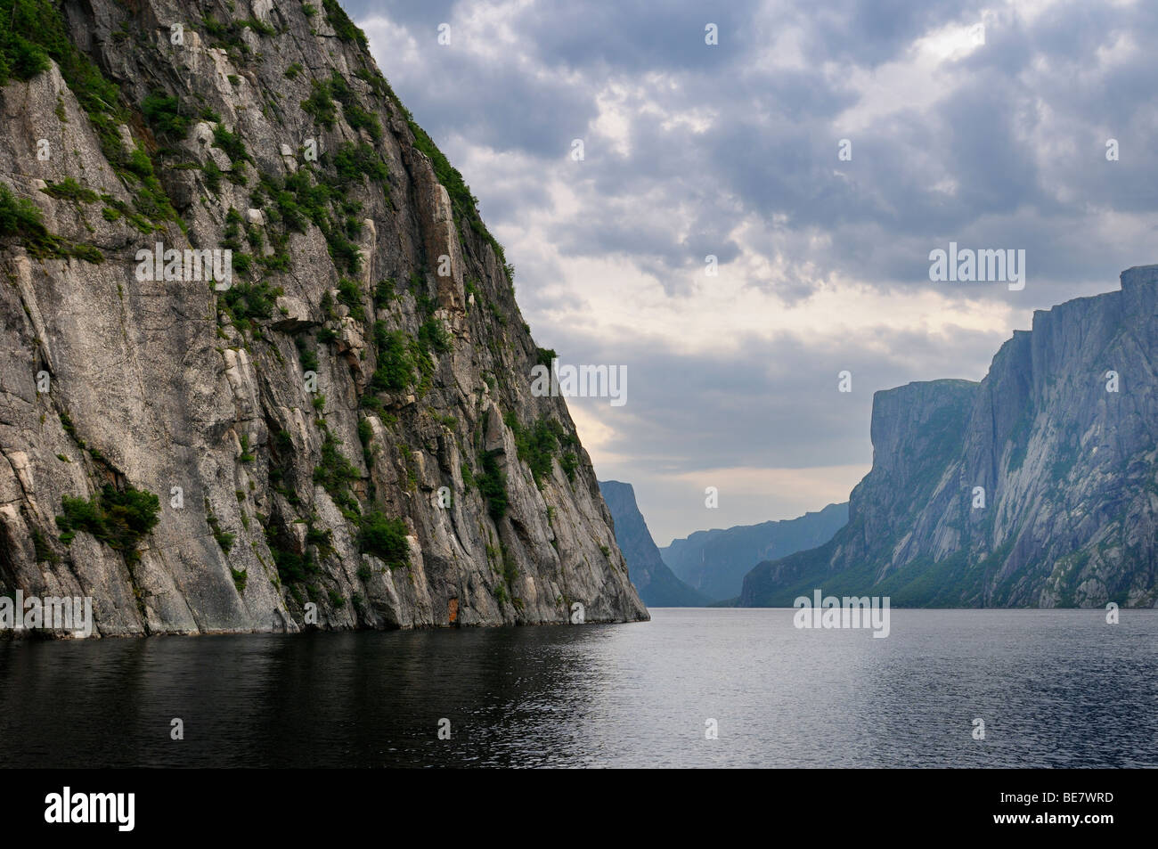 Clouds over steep Igneous rock wall at Western Brook Pond inland fjord ...