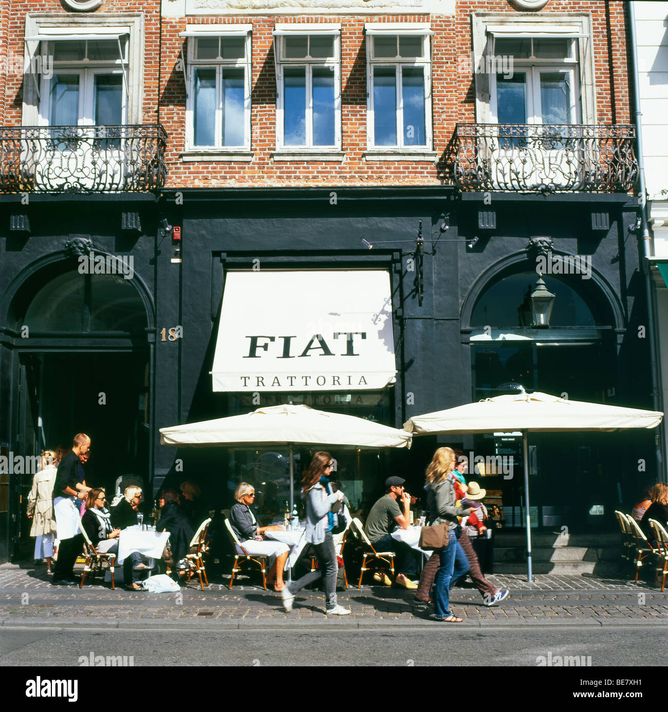People in summer eating outside at tables with umbrellas Fiat ...