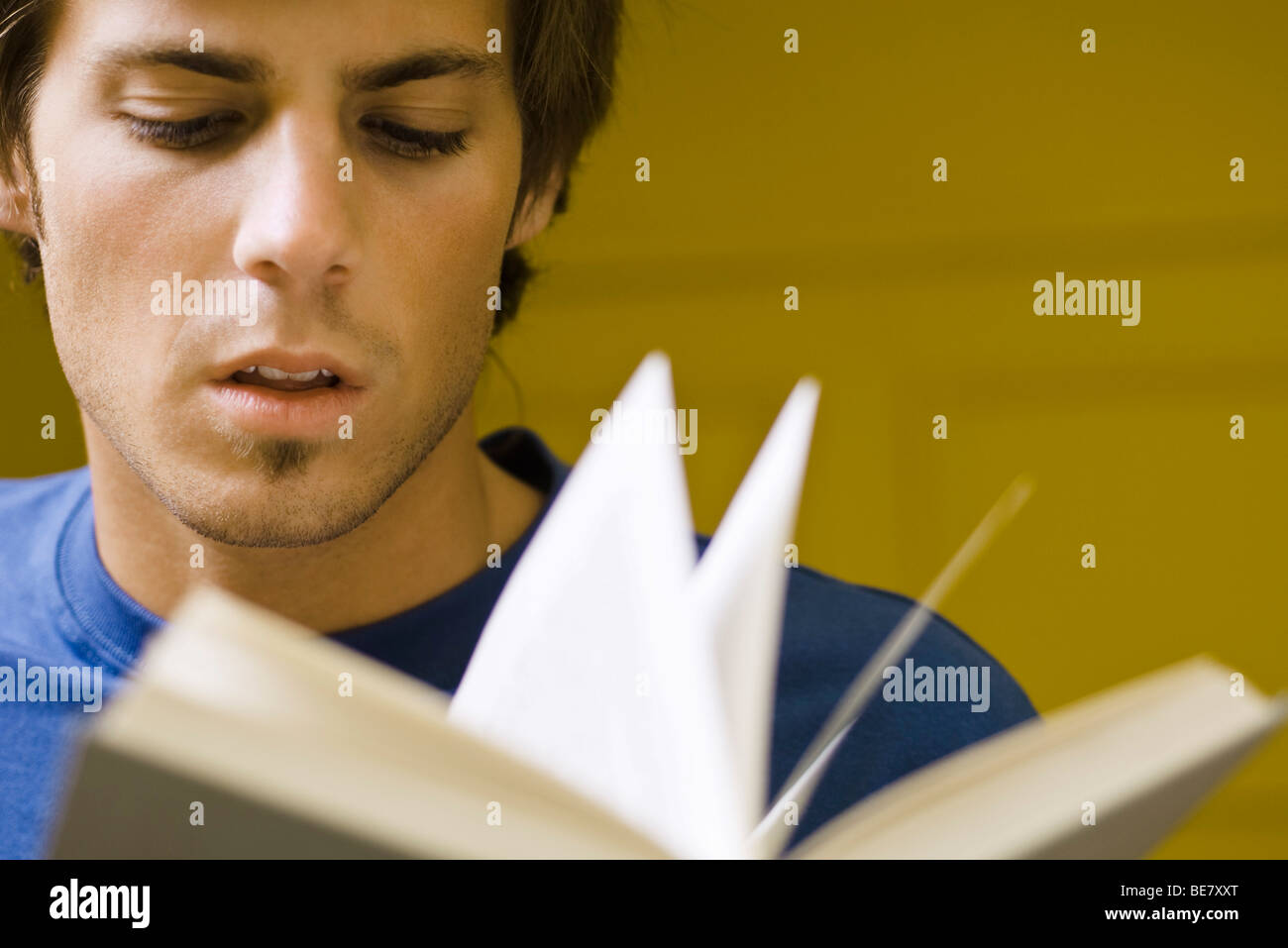 Young man reading book Stock Photo - Alamy