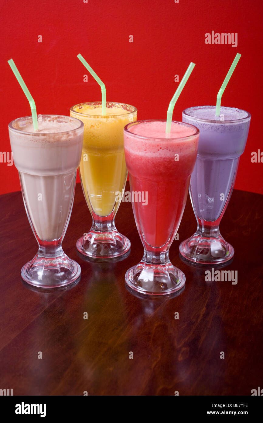 Four cool milkshakes against a brightly coloured wall. Flavours are ...