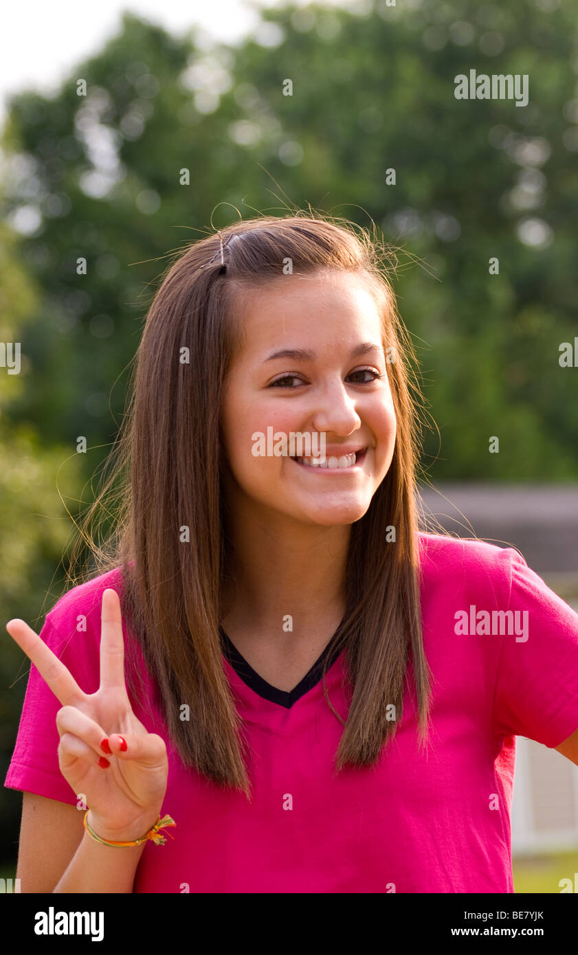 Portrait of young teenage girl aged 16 outside in yard at home with ...