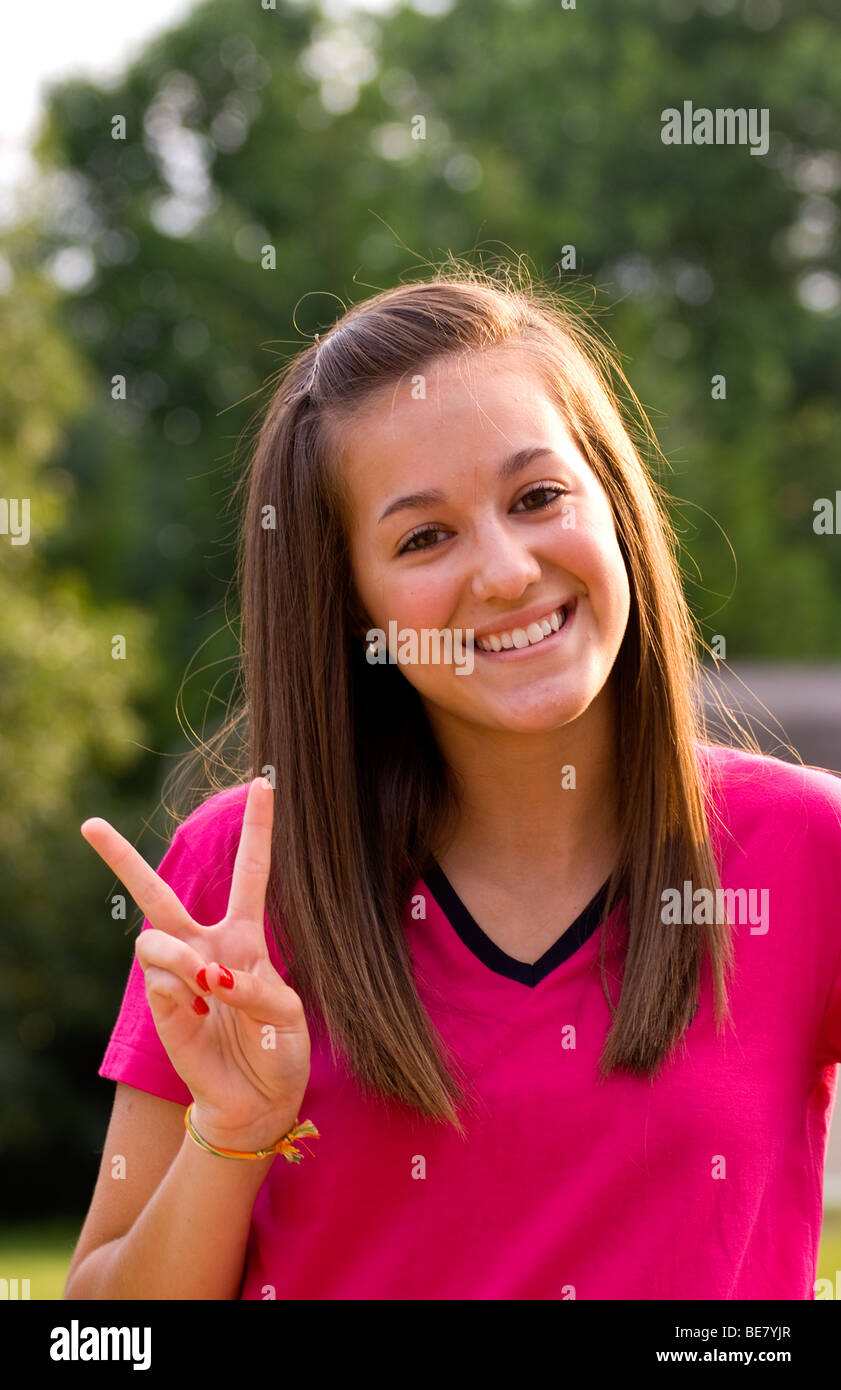Portrait of young teenage girl aged 16 outside in yard at home with ...