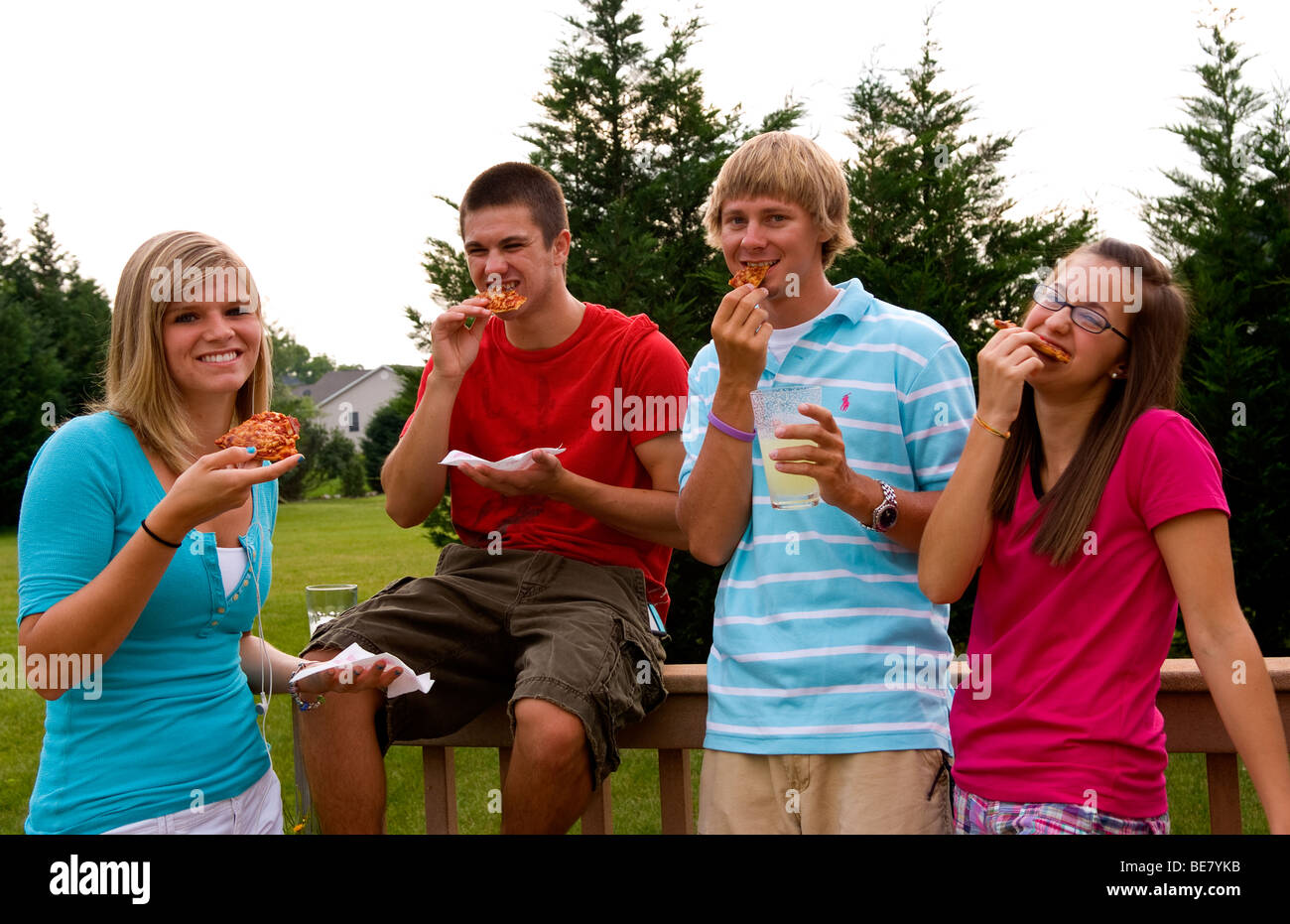 Modern teenagers hanging out at home as friends having pizza and ...