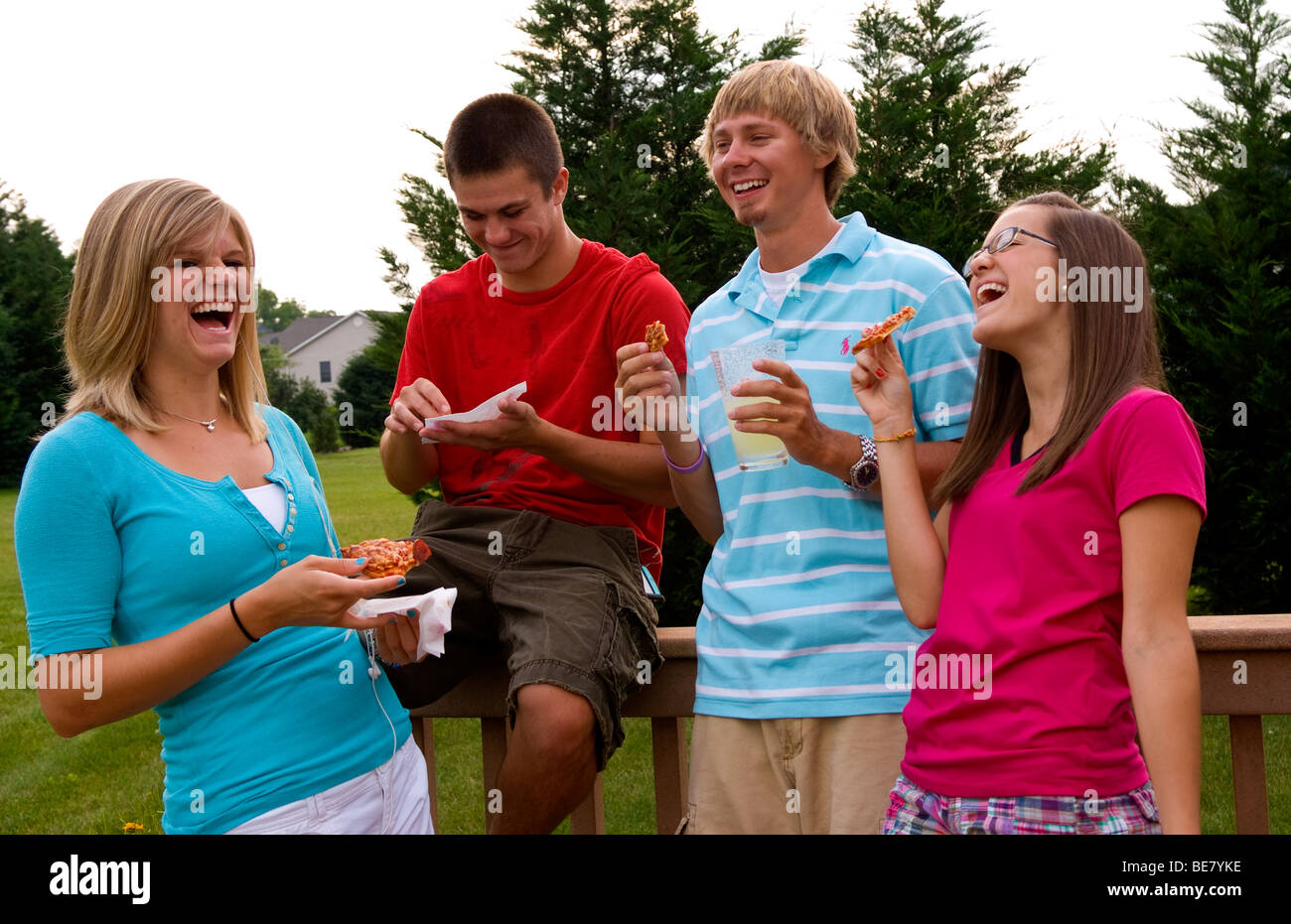 Modern teenagers hanging out at home as friends having pizza and ...