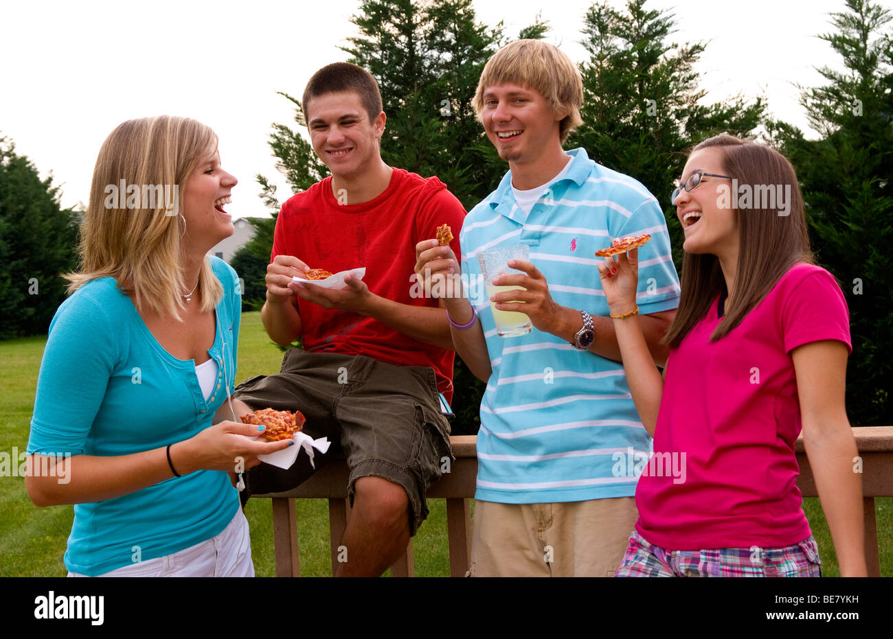 Modern teenagers hanging out at home as friends having pizza and ...