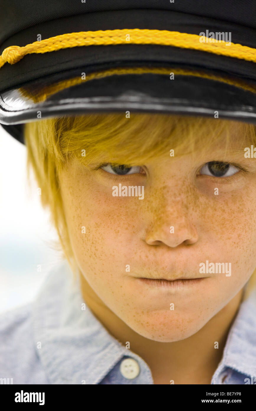 Boy wearing police officer's cap looking sternly at camera Stock Photo ...