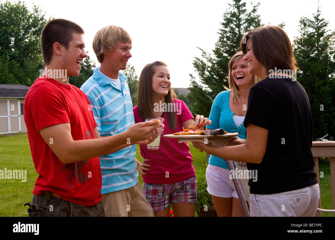 Modern teenagers hanging out at home as friends having pizza and ...