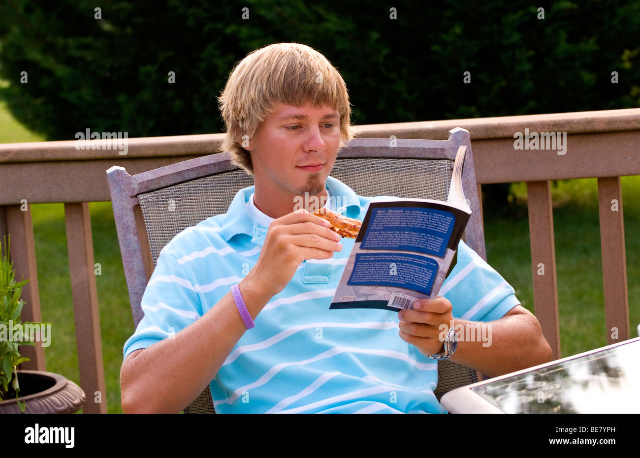 Modern teenager reading outside in yard at home portrait Stock Photo ...