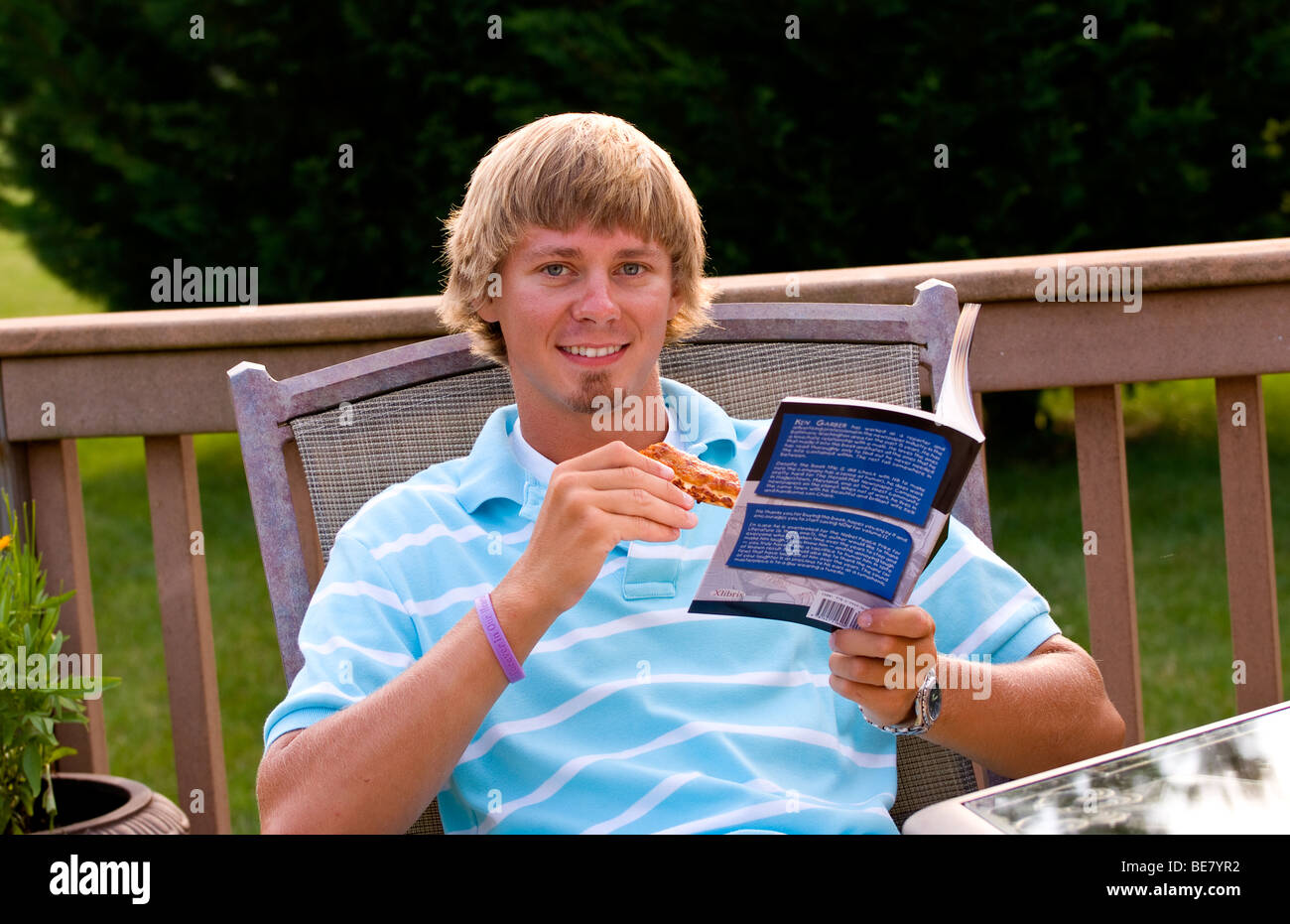 Modern teenager reading outside in yard at home portrait Stock Photo ...