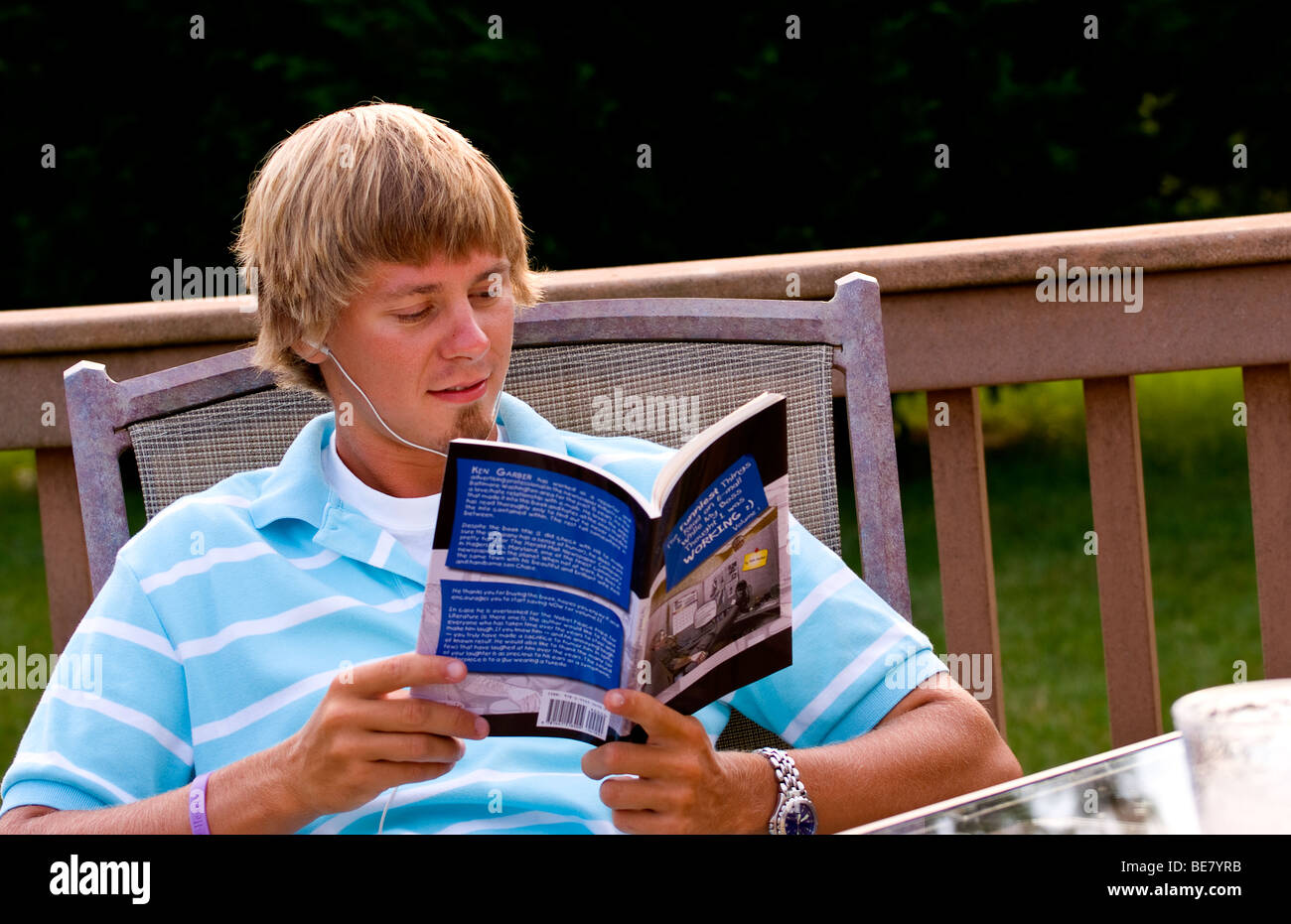 Modern teenager reading outside in yard at home portrait Stock Photo ...
