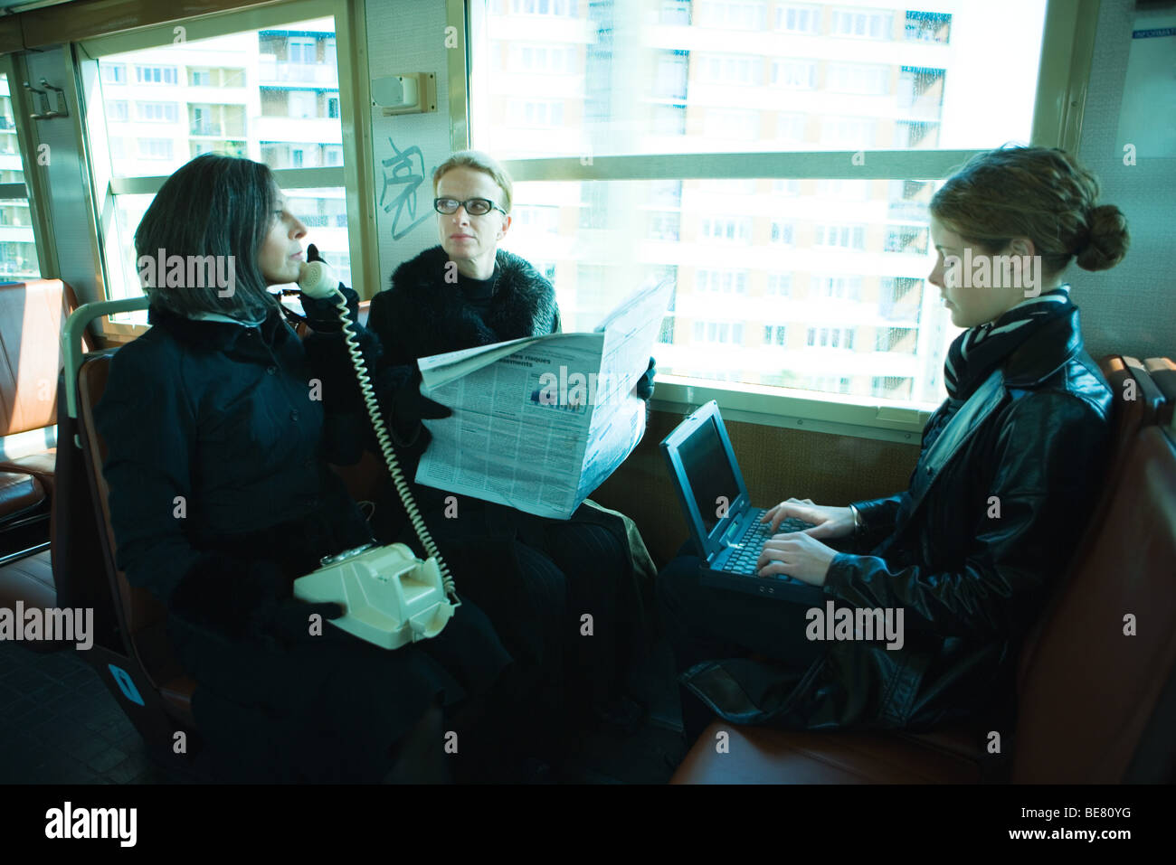 Commuters on train, one using landline phone Stock Photo - Alamy