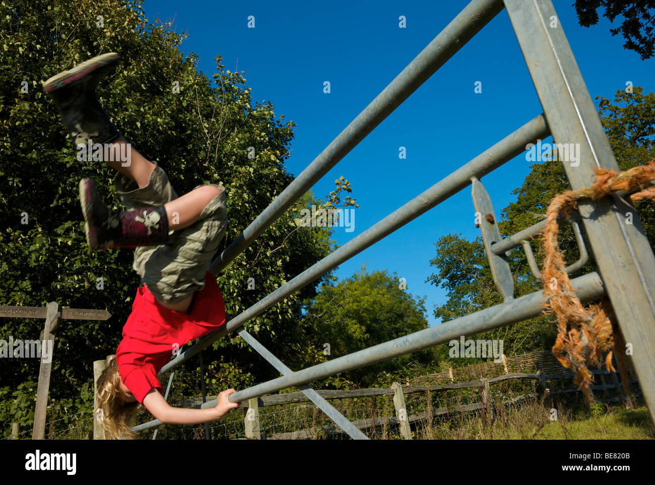 Young children playing on a farm gate Stock Photo - Alamy