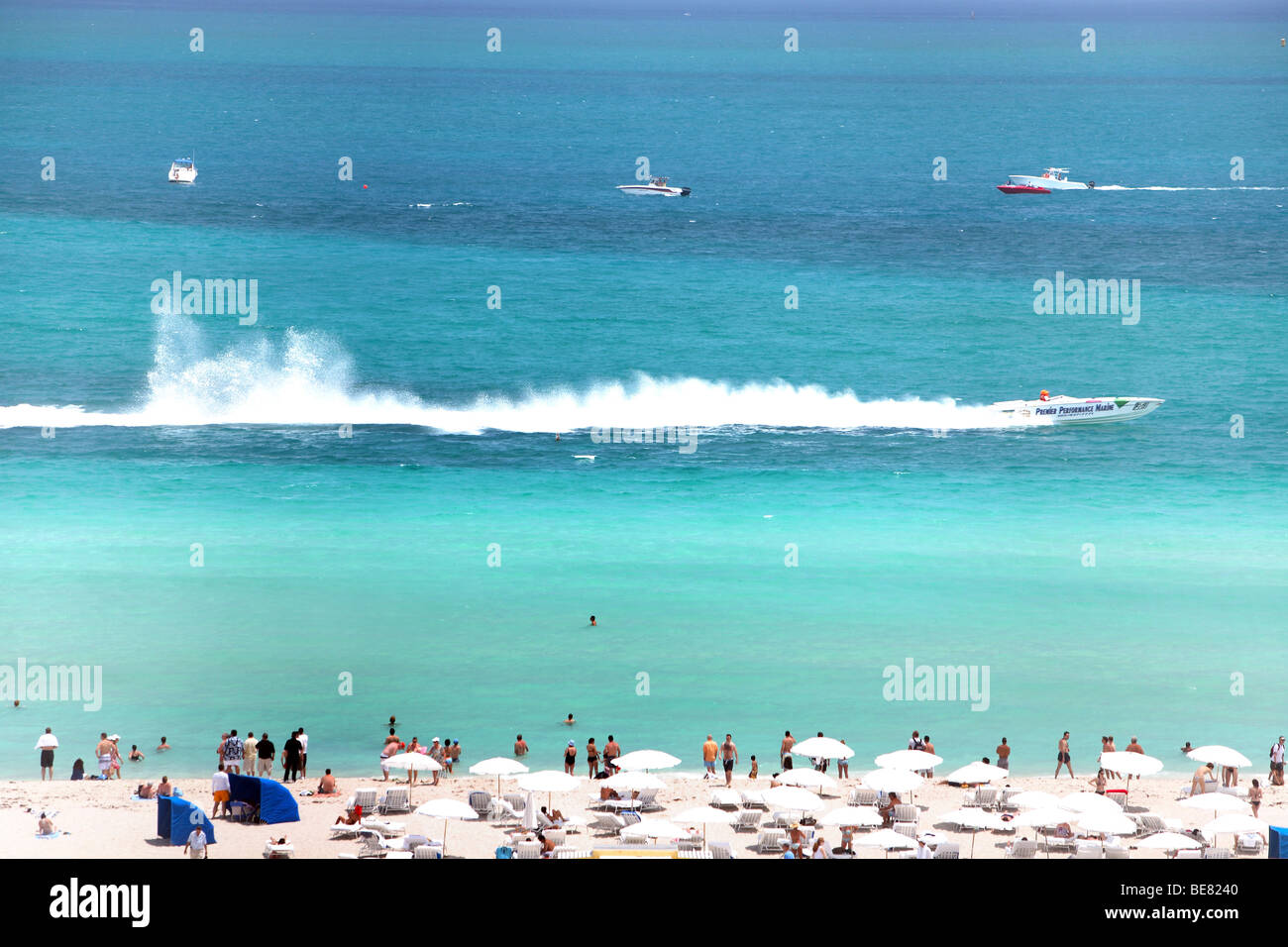 People on the beach watching a motor boat racing, South Beach, Miami ...