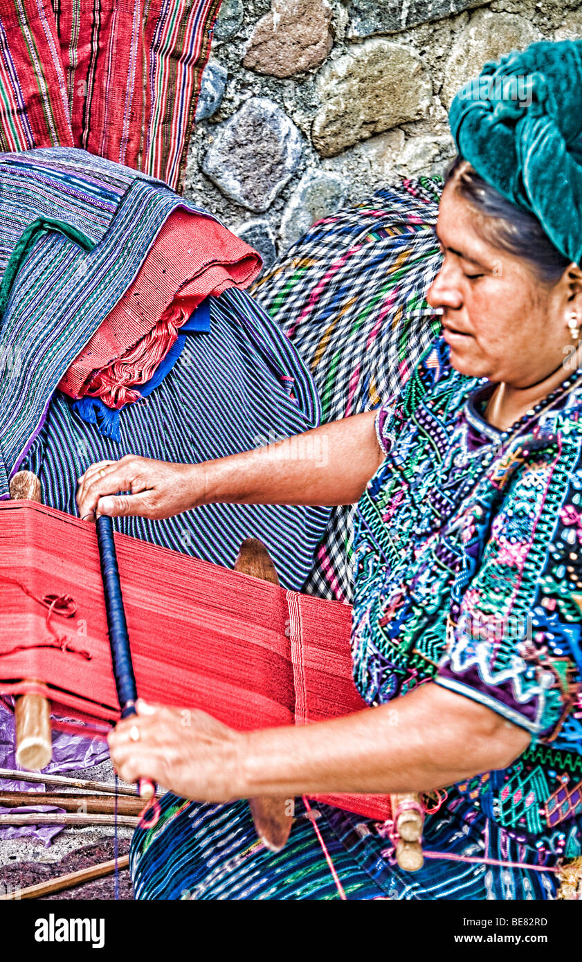 Costume woman in colorful print fabrics weaving clothes in ...