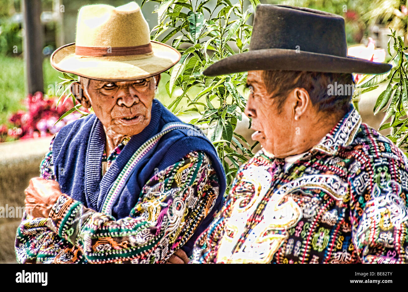 Great image of costume men in colorful print fabric talking in park ...