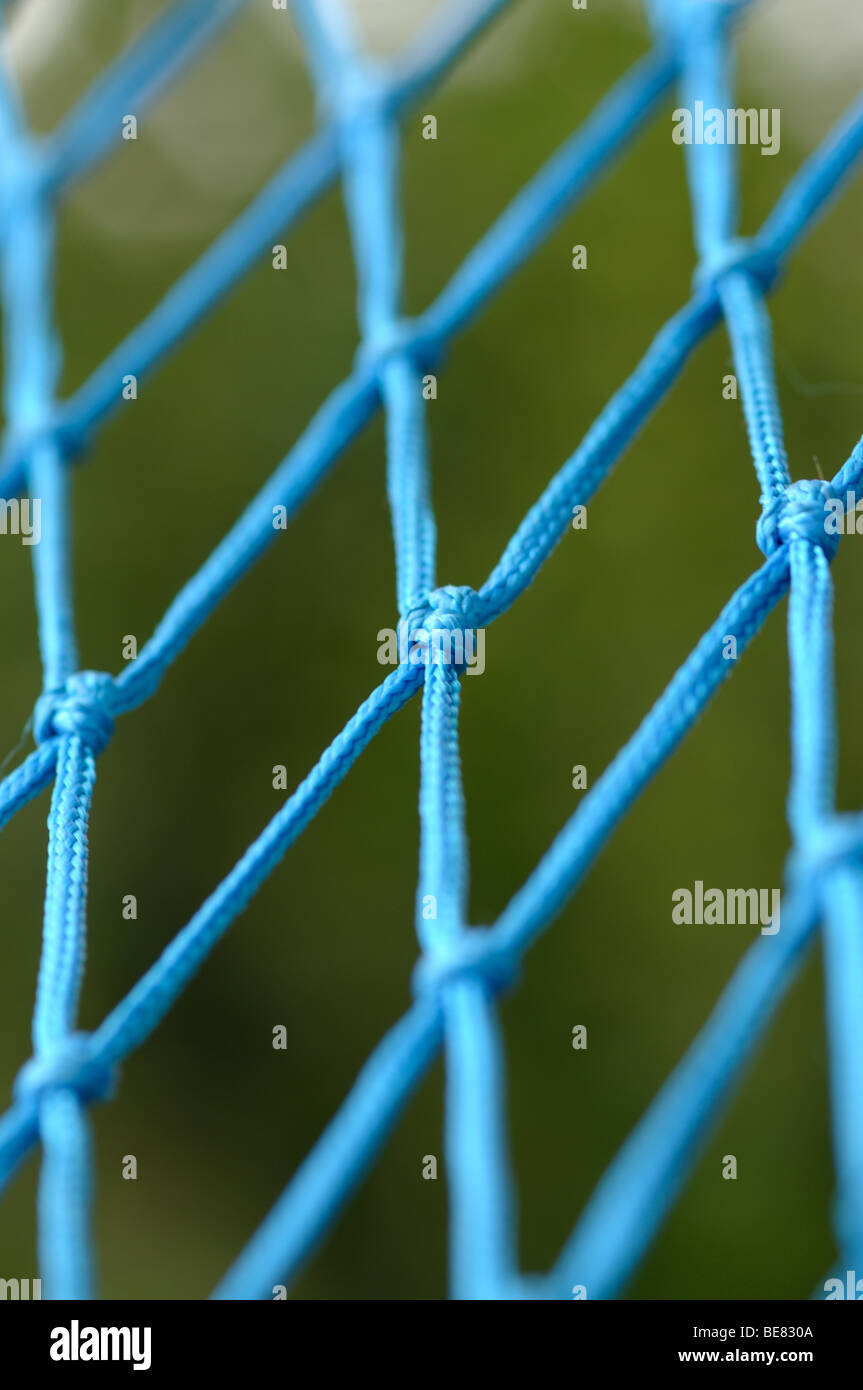 Closeup of a blue net on a green background Stock Photo - Alamy