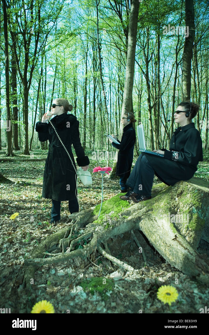 Females in woods using laptop computers and landline phone, all wearing ...