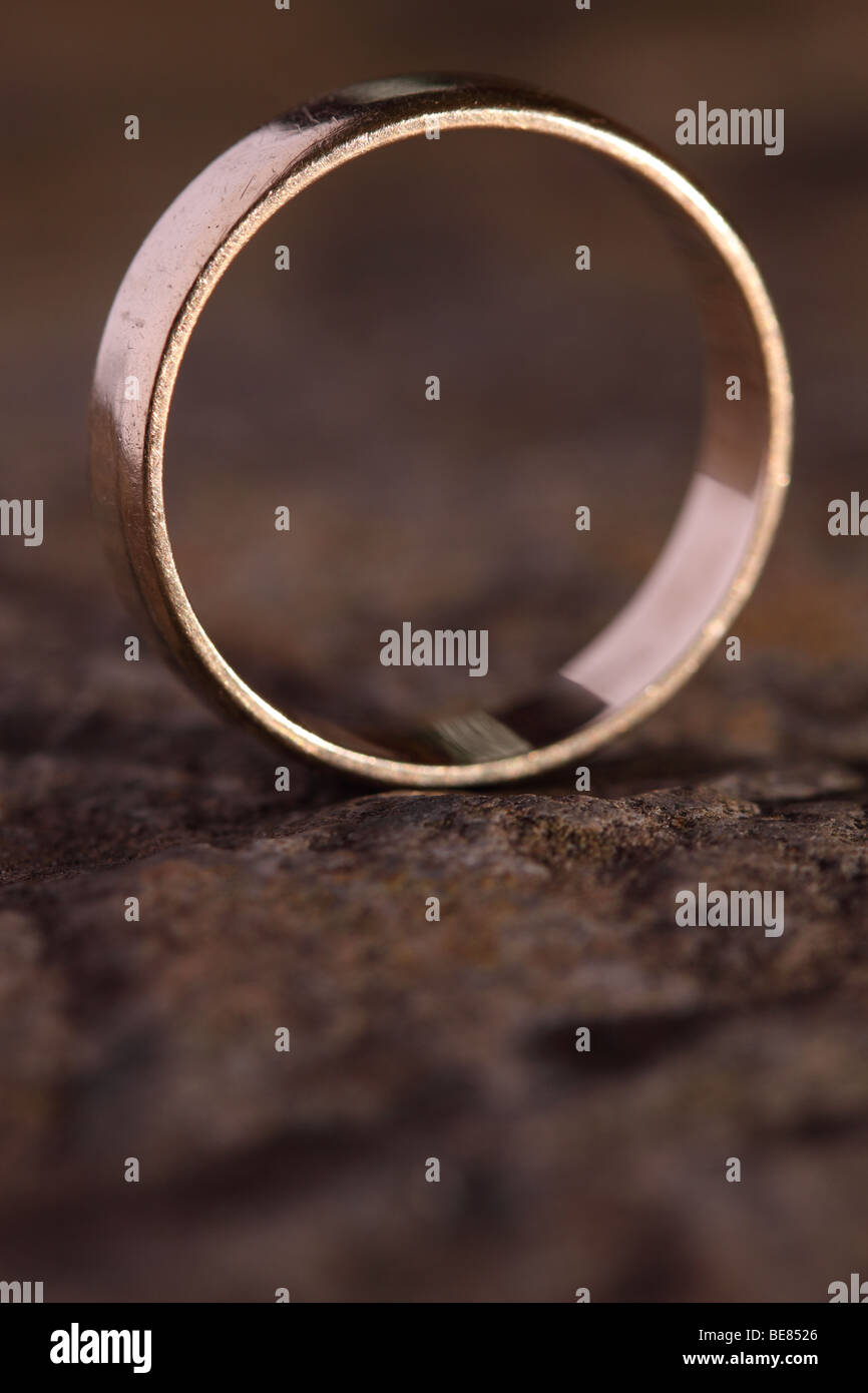 Golden gold wedding ring on stone Stock Photo - Alamy