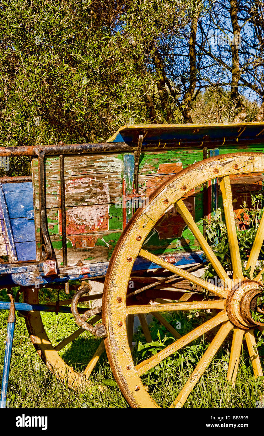 Beautiful colorful wagon and wheel in yard near Vila de Bispo in ...