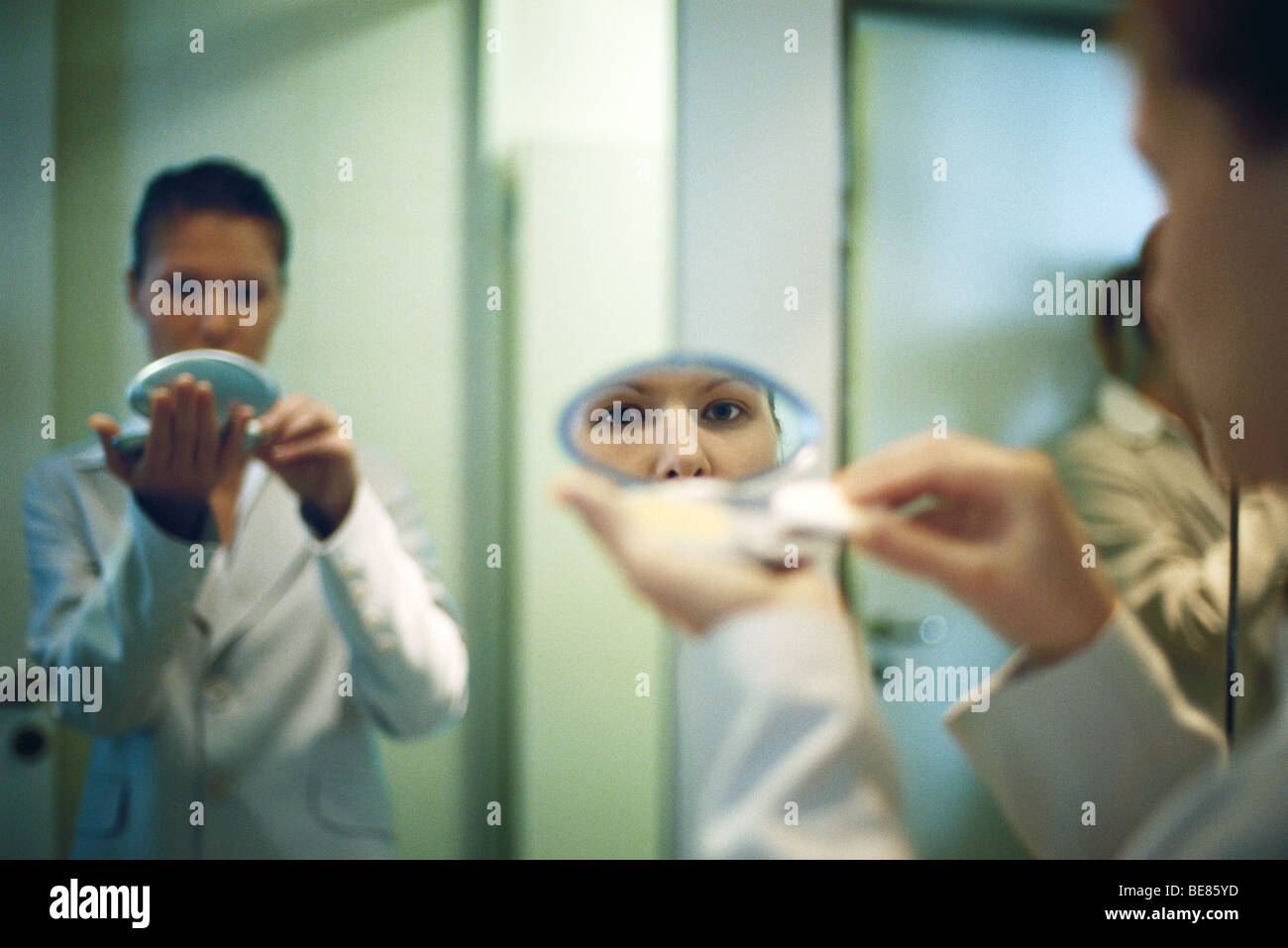 Woman looking mirror in washroom hi-res stock photography and images ...