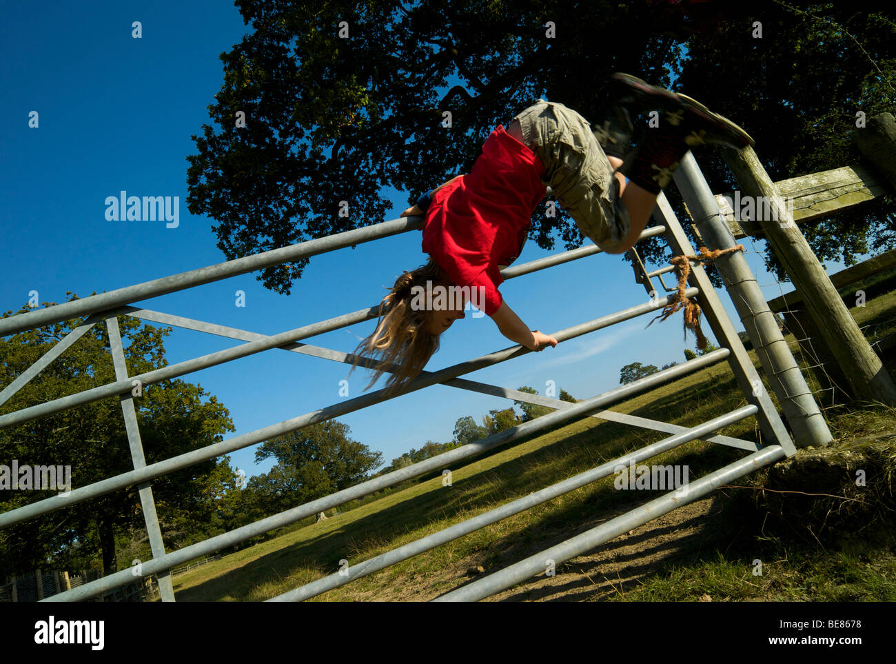 Young children playing on a farm gate Stock Photo - Alamy