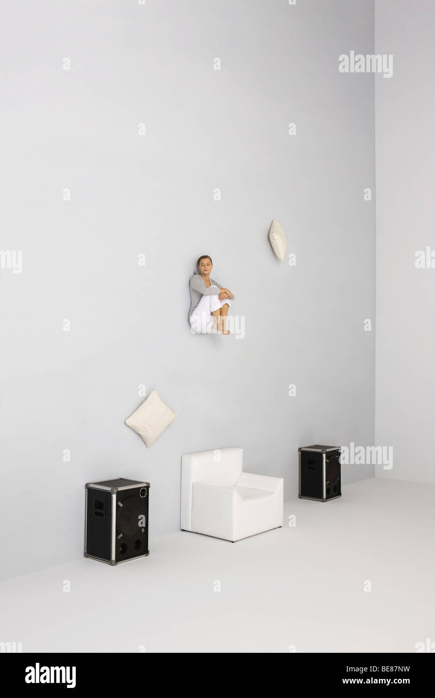 Woman floating in midair, listening to music through speakers Stock ...