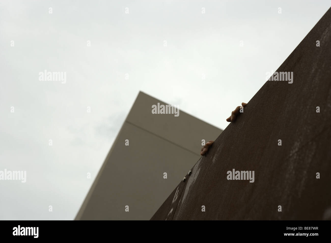 Hands holding on to balcony edge, low angle view Stock Photo - Alamy