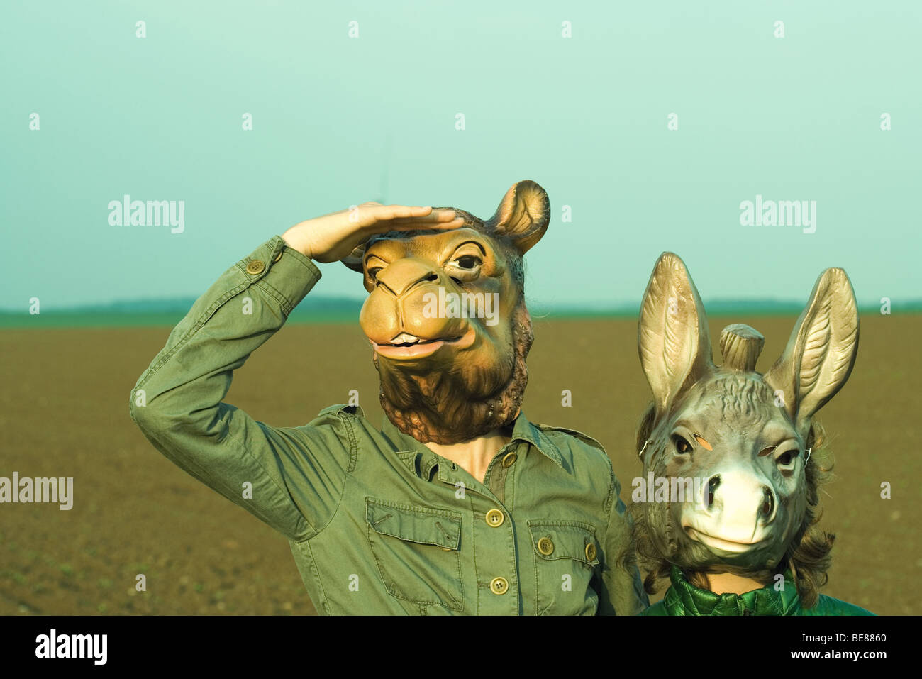 Two people in animal masks outdoors, one shading eyes with hand Stock ...
