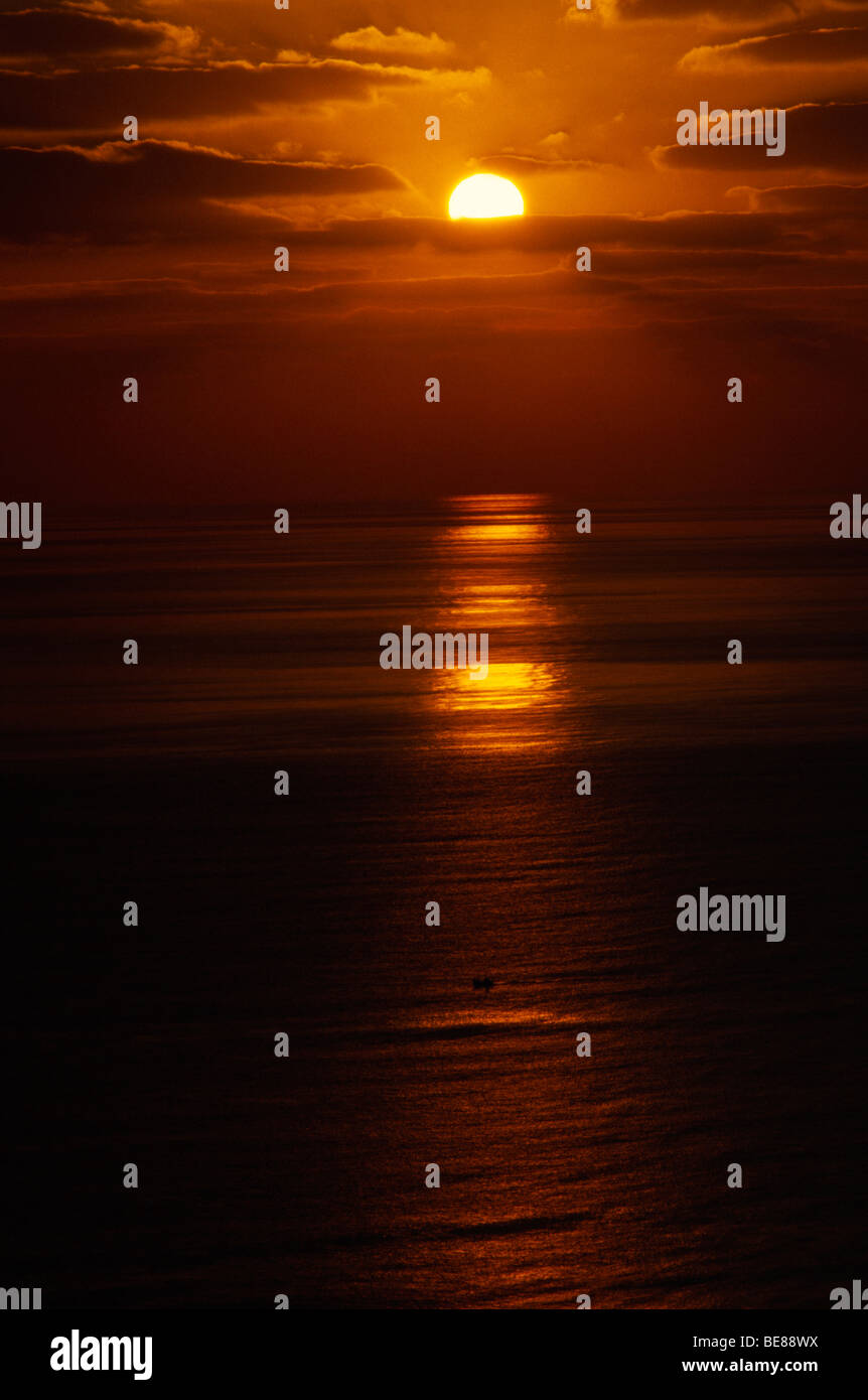 WEATHER Climate Red Sunset behind clouds over sea Stock Photo - Alamy