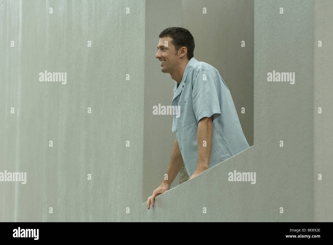 Man on balcony, smiling, side view Stock Photo - Alamy