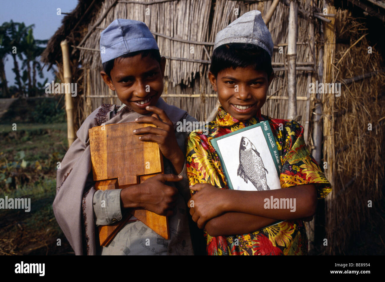 BANGLADESH Shariatpur Portrait of two smiling young boys carrying books ...