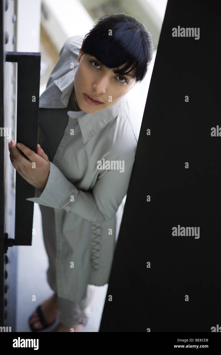 Woman opening door, looking at camera, high angle view Stock Photo - Alamy