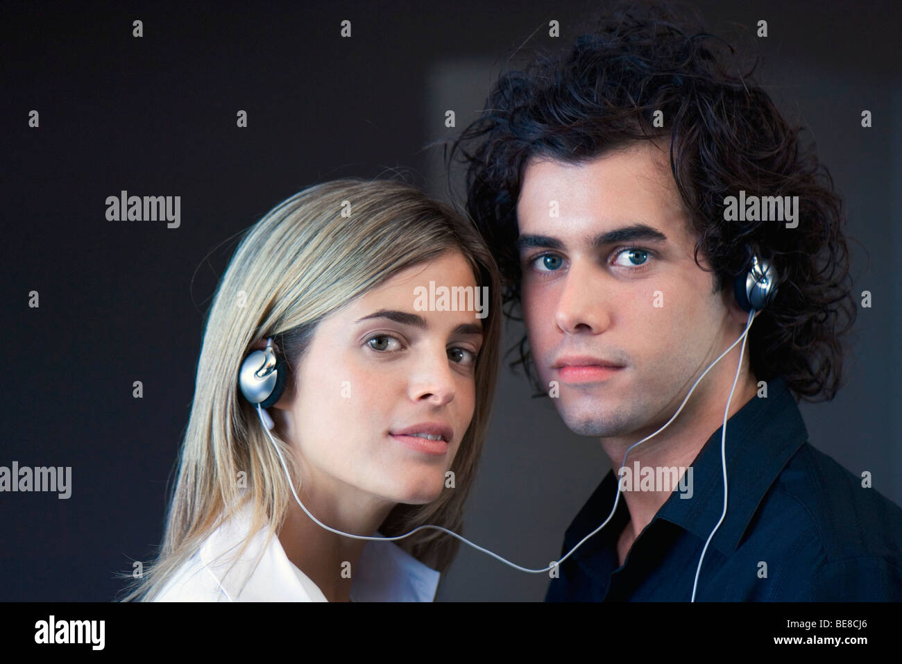 Couple sharing earbuds hi-res stock photography and images - Alamy