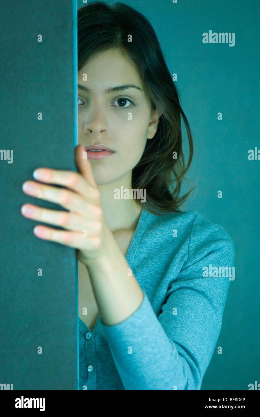 Woman peeking around corner hi-res stock photography and images - Alamy