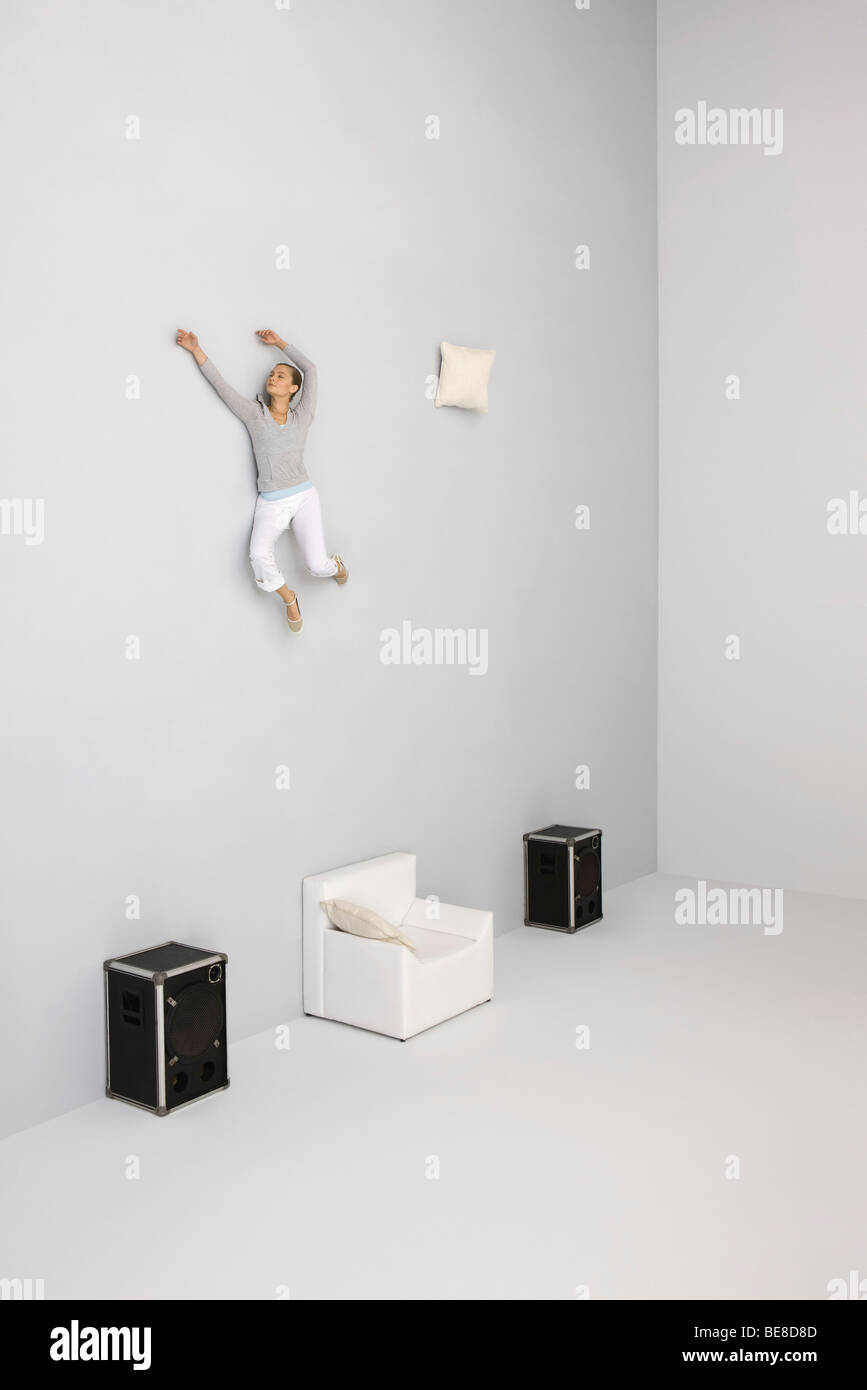 Woman with arms raised floating midair above armchair Stock Photo - Alamy